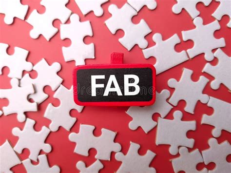 Wooden Board And White Puzzle With The Word Fab On Red Background