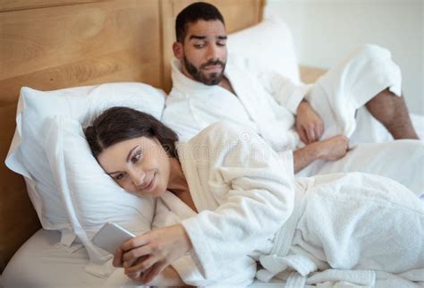 Marido Olhando Para A Esposa Mandando Mensagens No Telefone Com Suspeita De Infidelidade No