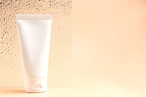 부드러운 유기농 천연 크림의 화이트 튜브 온베이지 배경 유리 프레임 장식 여름 페이셜 제품 선 로션 스킨케어를 위한 여성 위생 화장품 액세서리 공간을 복사합니다 0명에 대한