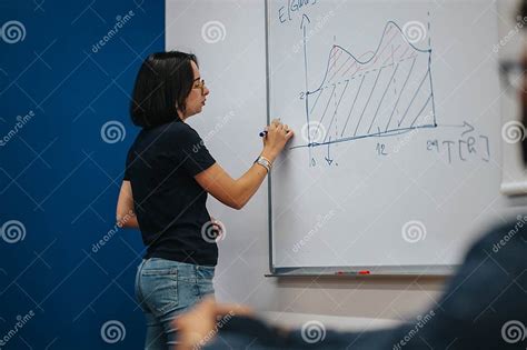 Student Presenting Graph Analysis On Classroom Whiteboard Stock Image