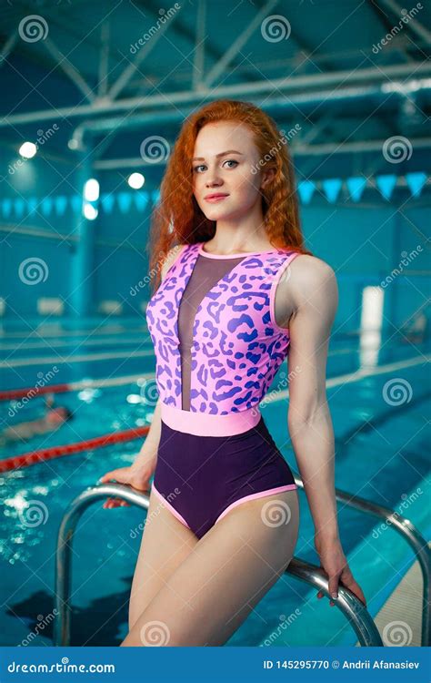 A Beautiful Red Haired Girl Stands On The Steps Of The Swimming Pool