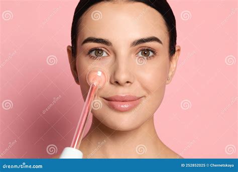 Woman Using High Frequency Darsonval Device On Pink Background Stock