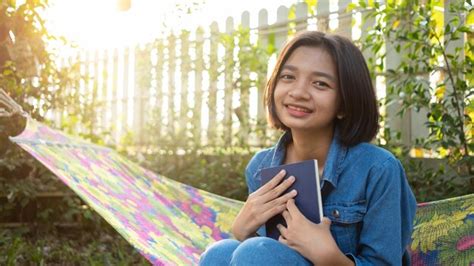 Premium Photo Smiling Teenage Girl Sitting On Hammock