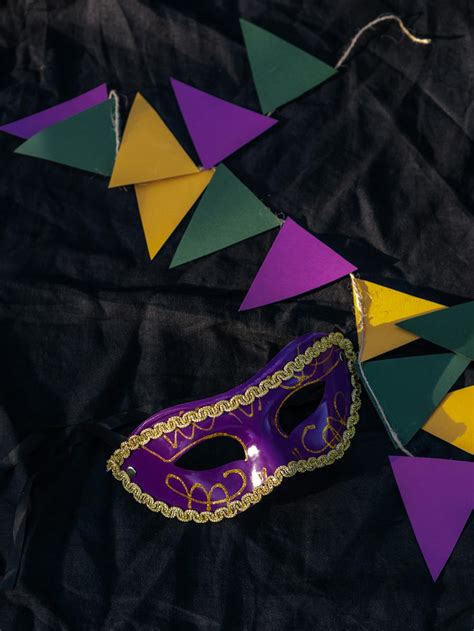 A Purple Mask Beside Colorful Banderitas On A Black Surface · Free