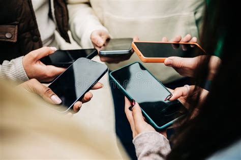Young Group Of People Using Mobile Phone Together Standing Outdoor