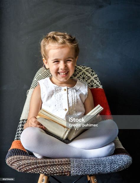 Gadis Kecil Duduk Di Kursi Dan Membaca Buku Foto Stok Unduh Gambar Sekarang Duduk Posisi