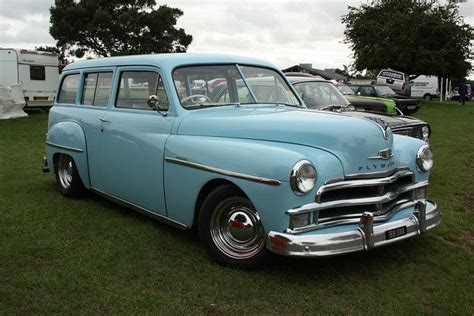An Old Blue Car Is Parked In The Grass