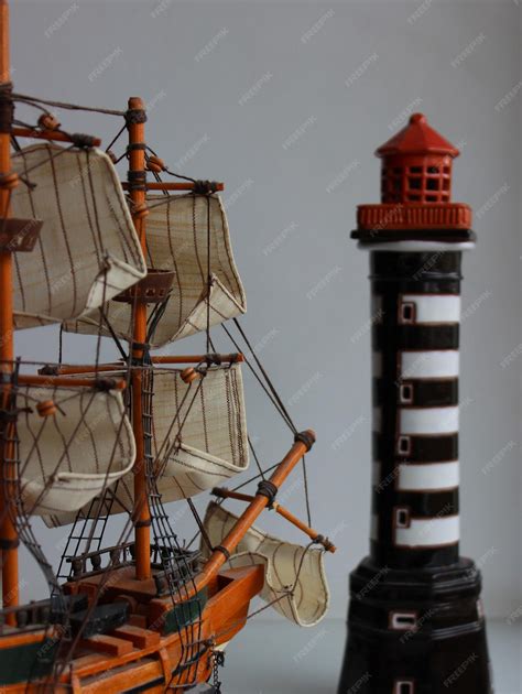 Premium Photo Back Angle View Of Scale Model Of Sailing Ship Toward The Toy Lighthouse Tower