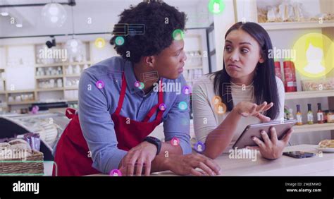 Image Of Media Icons Over Diverse Shop Assistant And Customer Talking