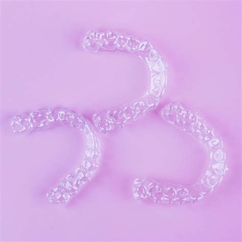 Premium Photo Invisible Dental Teeth Brackets Tooth Aligners On Pink Background Plastic Braces