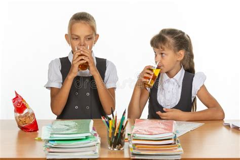Two School Friends Drink Juice At A Table In A School Class Stock Image