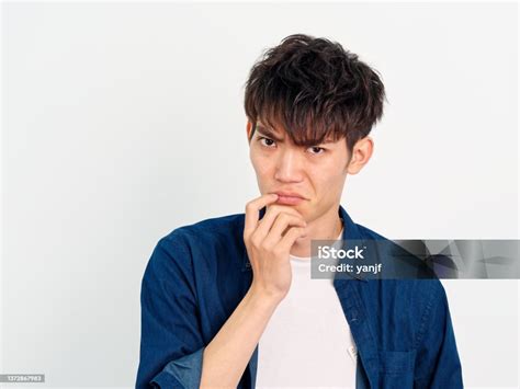 흰색 벽 배경에 포즈 파란색 셔츠에 곱슬 검은 머리를 가진 잘 생긴 중국 젊은이의 초상화 혐오스무분이 있는 표정으로 입에 손을 대고 불행해 보이며 정면을 바라보고 있다 20