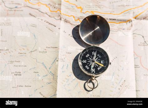 From Above Of Retro Compass Placed On Paper Map Showing Concept Of