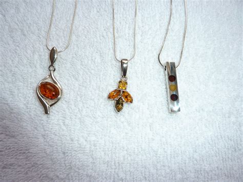 Three Different Styles Of Amber Necklace On Silver Chains The First Is