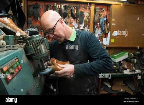 An Old Fashioned Shoe Repair Cobbler Fixes Shoes In His Busy Shop
