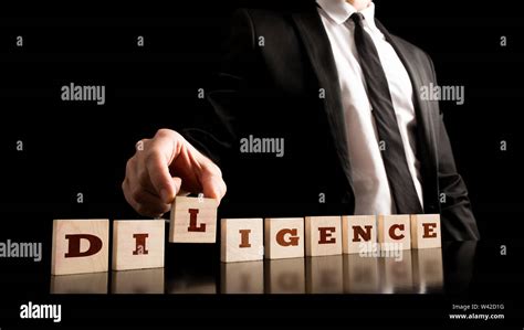 Close Up Businessman In Black Business Suit Arranging Small Wooden