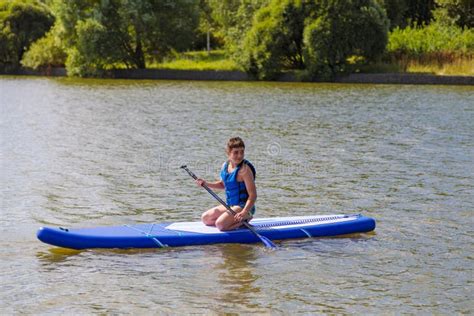 Young Guy Sitting On A Sup Board On A Lake Stock Image Image Of Excitement Ascent 329366691