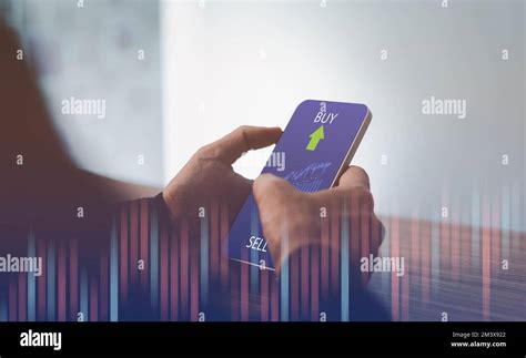 Male Trader Investor Analyst Holding Smartphone In Hand Analyzing Stock Market Trading Charts