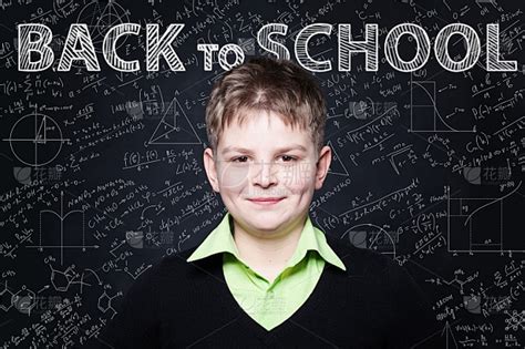 年轻的学生在黑板上微笑。返回学校背景