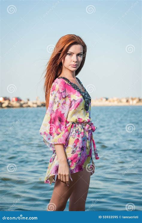 Young Red Hair Girl In Multicolored Blouse Posing On The Beach Sensual