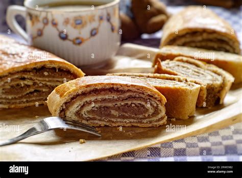 In The Foreground Nut Cake On A Plate In The Background A Cup Of