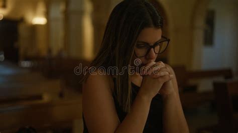 Se Ve A Una Hermosa Joven Hispana Rezando Dentro De Una Iglesia