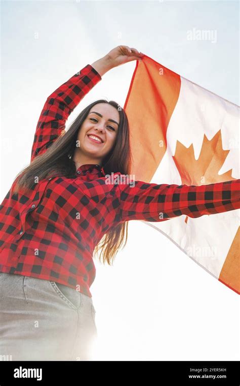 Young Millennial Brunette Woman Holding The National Flag Of Canada