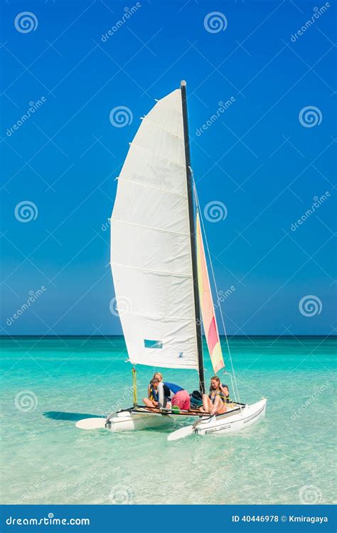 Two Girls Sailing In Yellow Kayak Next To A Tropical Exotic Island