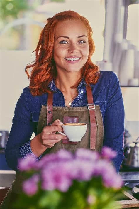 A Beauty Redhead Girl Drinks Coffee Sitting Near The Coffee Shop