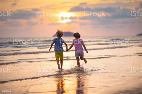 Foto De Criança Brincando Na Praia Do Oceano Garoto No Mar Do Pôrdosol