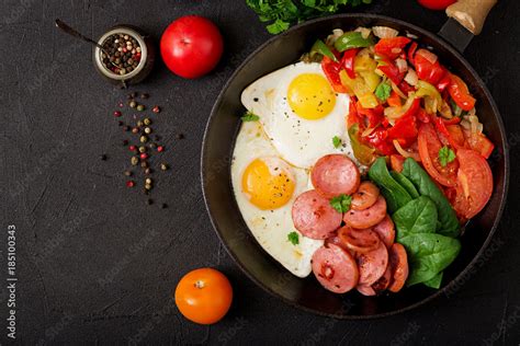 Breakfast Fried Eggs With Sausage And Vegetables In A Frying Pan On A