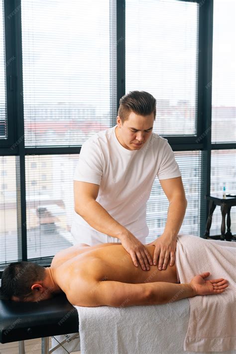 Premium Photo Vertical Shot Of Professional Male Masseur With Strong