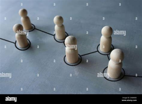 Selective Focus Image Chain Of Wooden Dolls Connected By Lines