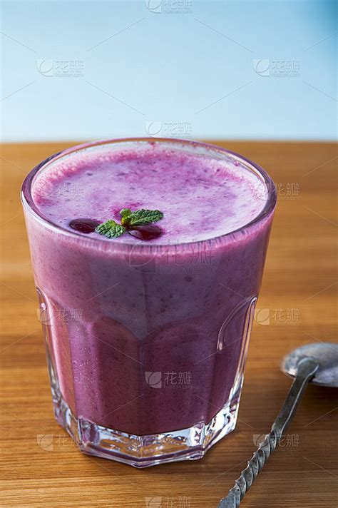 木桌上放着樱桃、薄荷叶和勺子