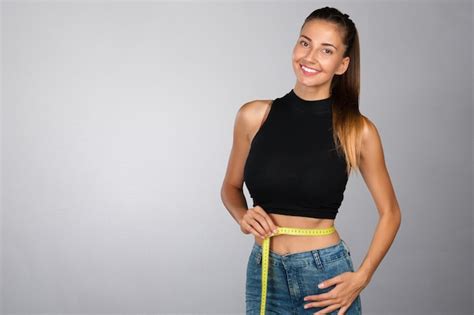 Premium Photo Athletic Slim Woman Measuring Her Waist By Measure Tape