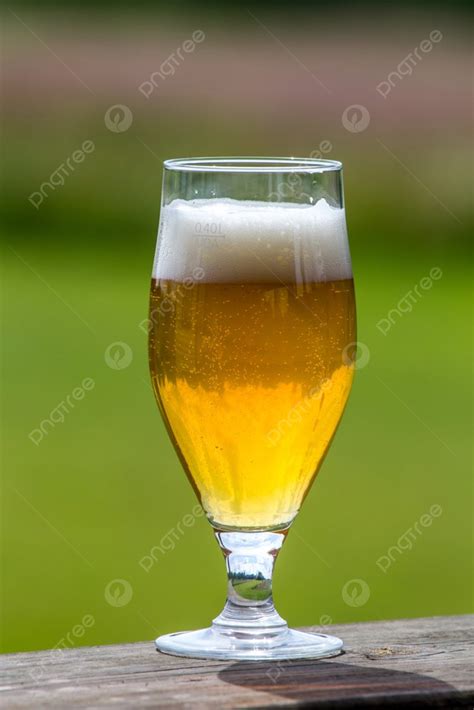 Vaso De Cerveza Ligera Con Espuma Y Burbujas Sobre Una Mesa De Madera