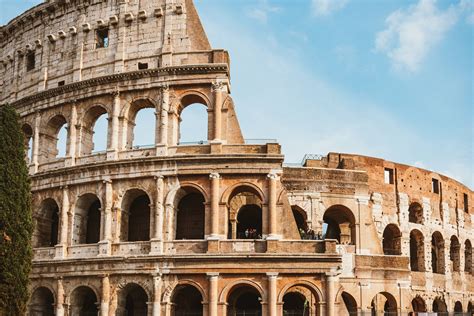 Download Colosseum Ruins In Front Of A Cloudy Sky Wallpaper