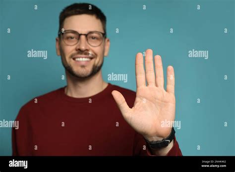 Left Handed Man Against Light Blue Background Focus On Palm Stock Left Handed Man Against Light Blue Background Focus On Palm Stock