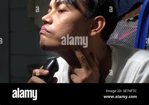Close Up Of A Southeast Asian Man Trimming His Beard And Mustache With