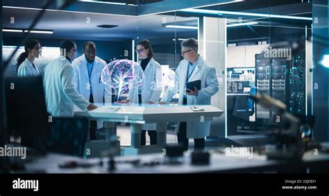 Diverse Group Of Neuroscientists Having A Meeting Around Futuristic Computer Hologram Of Human