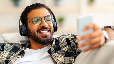 Handsome Arab Guy Watching Movie Using Wireless Headset And Cellphone Stock Image Image Of