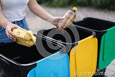 Middle Selection Of Female Hold Two Different Type Of Rubbish Plastic Bottle And Egg Carton And