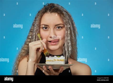 Fun Pretty Curly Blond Hair Girl With Sweet Dessert On Cyan Background Lick Lips Stock Photo Alamy