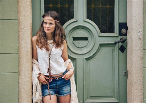 Portrait Of Trendy Hipster Woman Standing Outdoors Against Door Stock