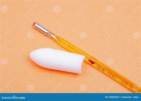 Thermometer And Suppository Medication On Orange Rectal Drug