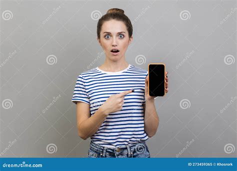 Woman Pointing At Cell Phone And Looking With Surprised Expression