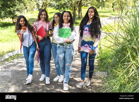 A Group Of Latina Teenage Women Walk Smiling To Class With Backpacks