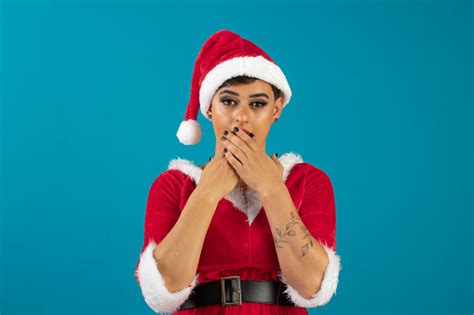 산타클로스 복장과 모자를 쓴 젊은 여성 파란색 배경과 크리스마스 테마가 있는 스튜디오 사진 12월에 대한 스톡 사진 및 기타 이미지 Istock