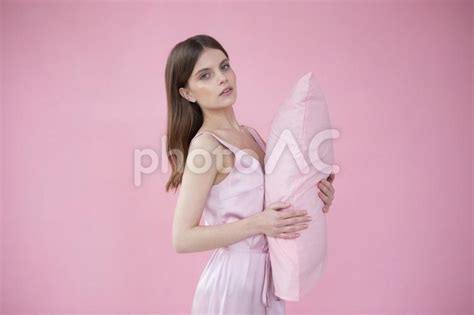 枕を胸につけてカメラ目線な女性 No 24473783｜写真素材なら「写真ac」無料（フリー）ダウンロードok
