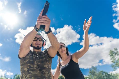 Female Instructor Showing Male Client Wearing Safety Gear And Camo